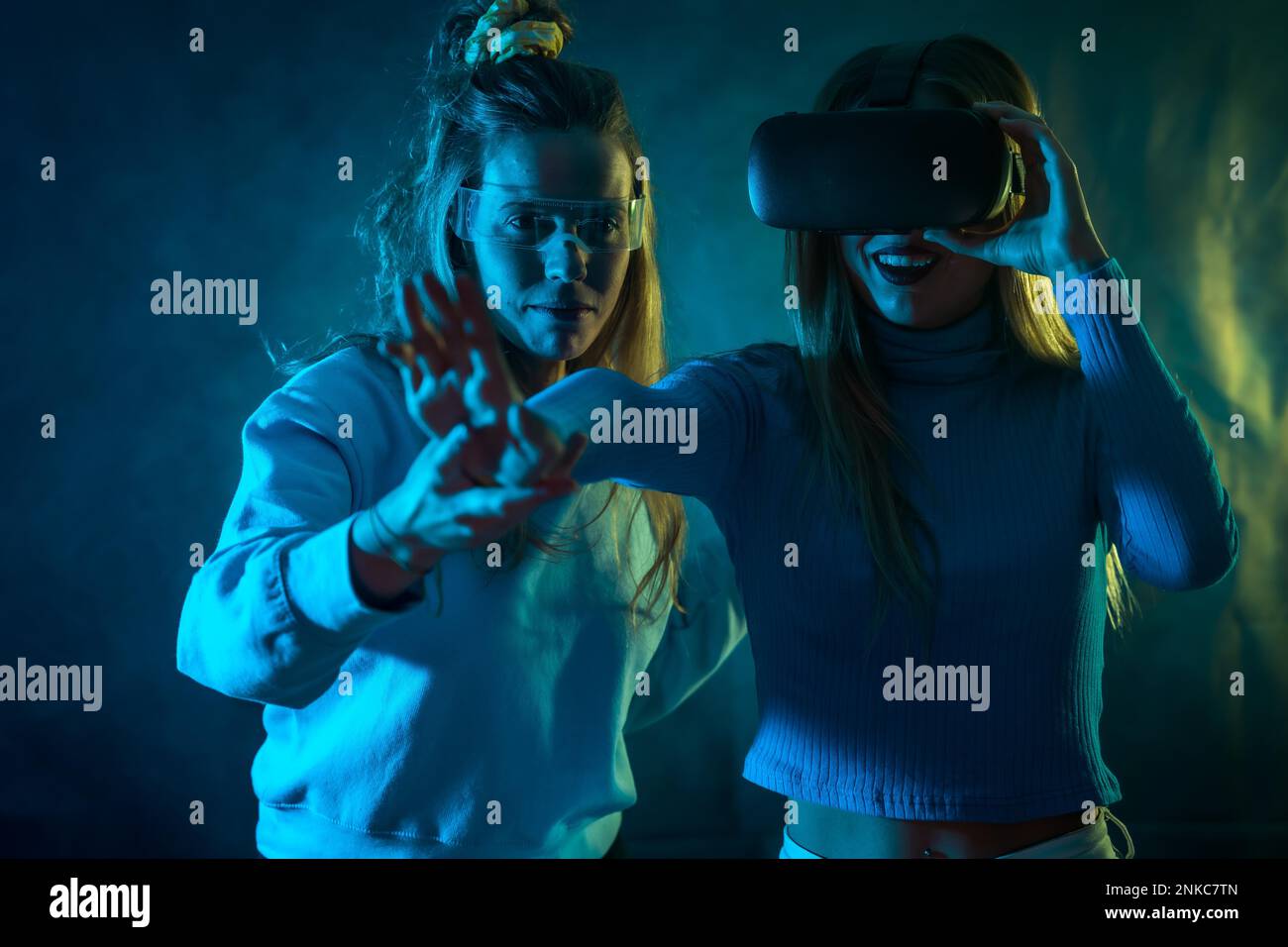 Two futuristic women in vr glasses, looking at the metaverse, blue ...