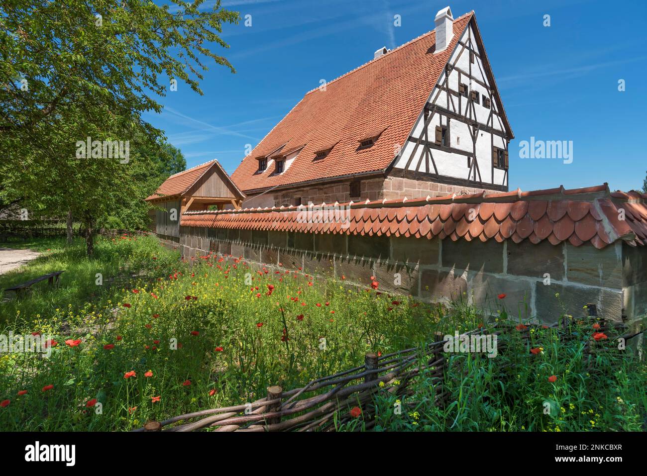 Reconstruction of a medieval bathhouse enclosed by a wall with plain ...