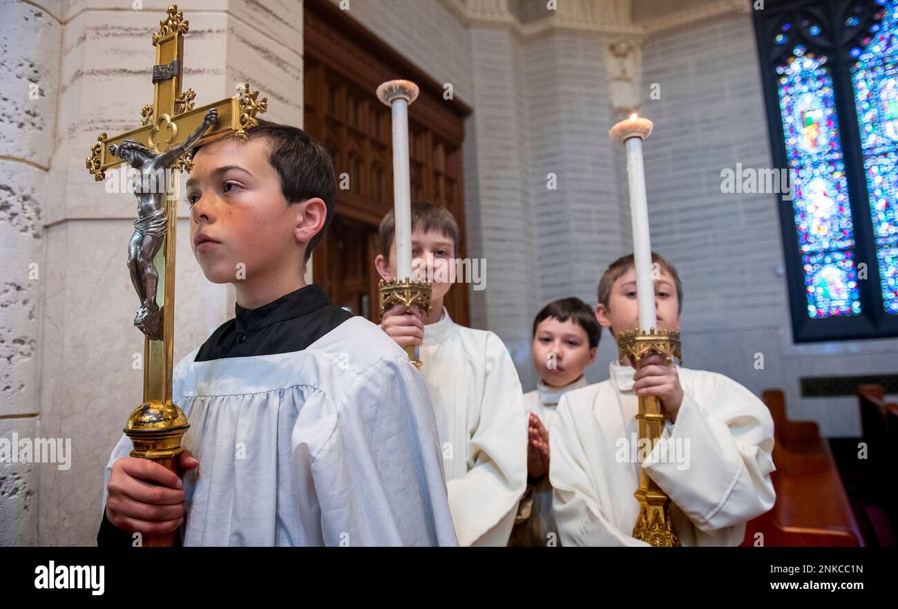 Altar servers wait for the nod to fall in line with the procession at the start of Easter Mass ...