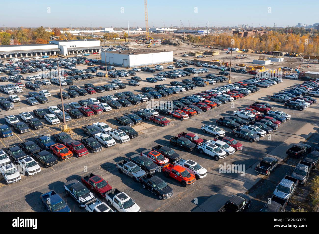Ford pickup trucks are parked in a vacant warehouse parking lot ...