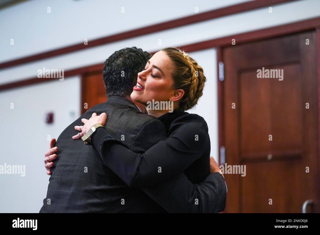 Actor Amber Heard gets a hug as she arrives in the courtroom at the ...