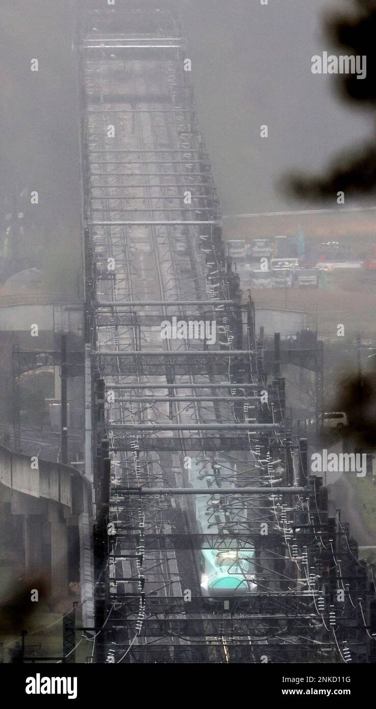 Tohoku Shinkansen bullet train passes an accident site that a train ...