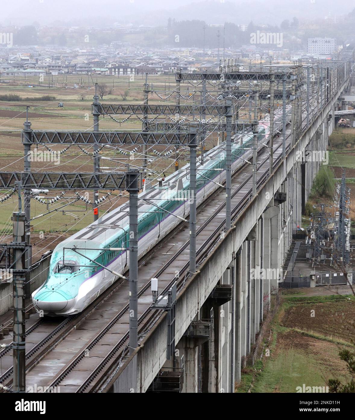 Tohoku Shinkansen bullet train passes an accident site that a train ...
