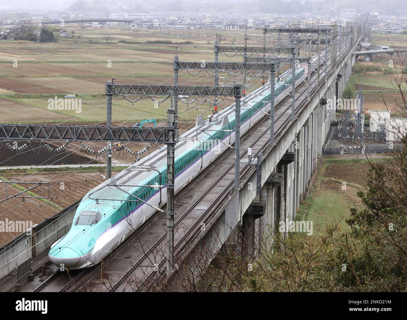 Tohoku Shinkansen bullet train passes an accident site that a train ...