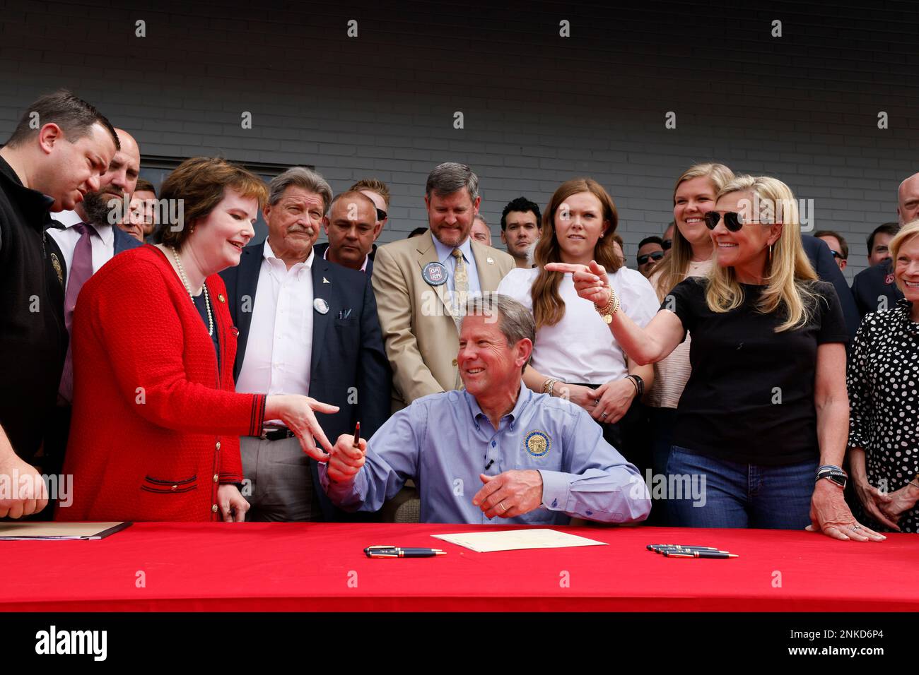 Gov. Brian Kemp hands a pen to Rep. Mandi Ballinger after he signed a ...