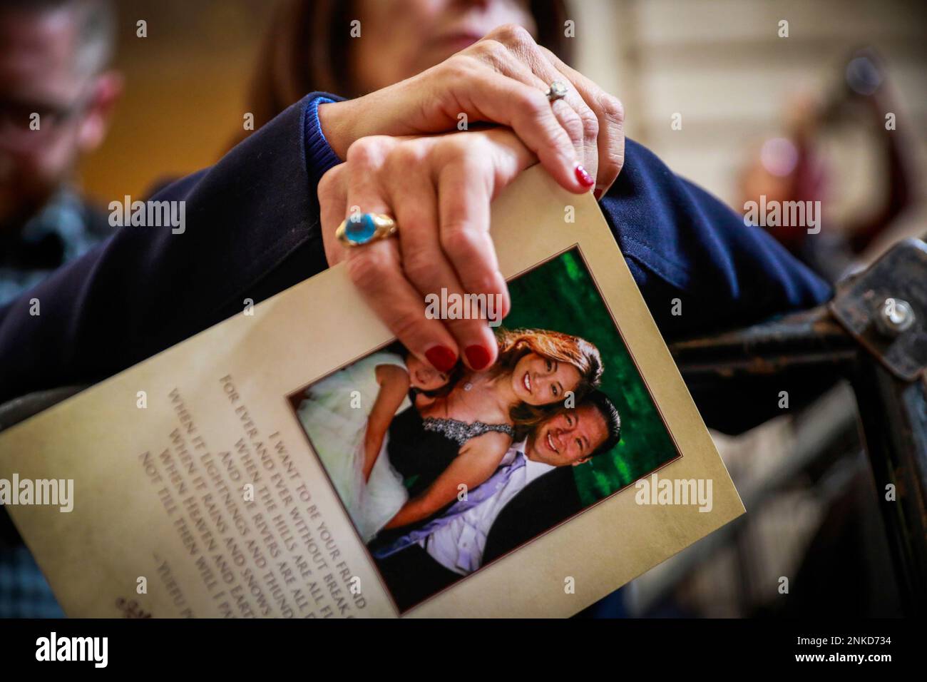 A woman holds on to the service program where a picture of Jeff Adachi ...