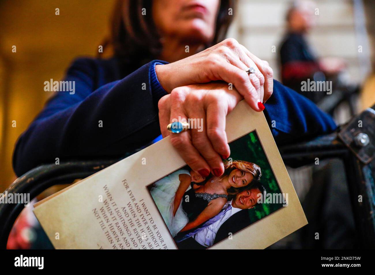 A woman holds on to the service program where a picture of Jeff Adachi ...