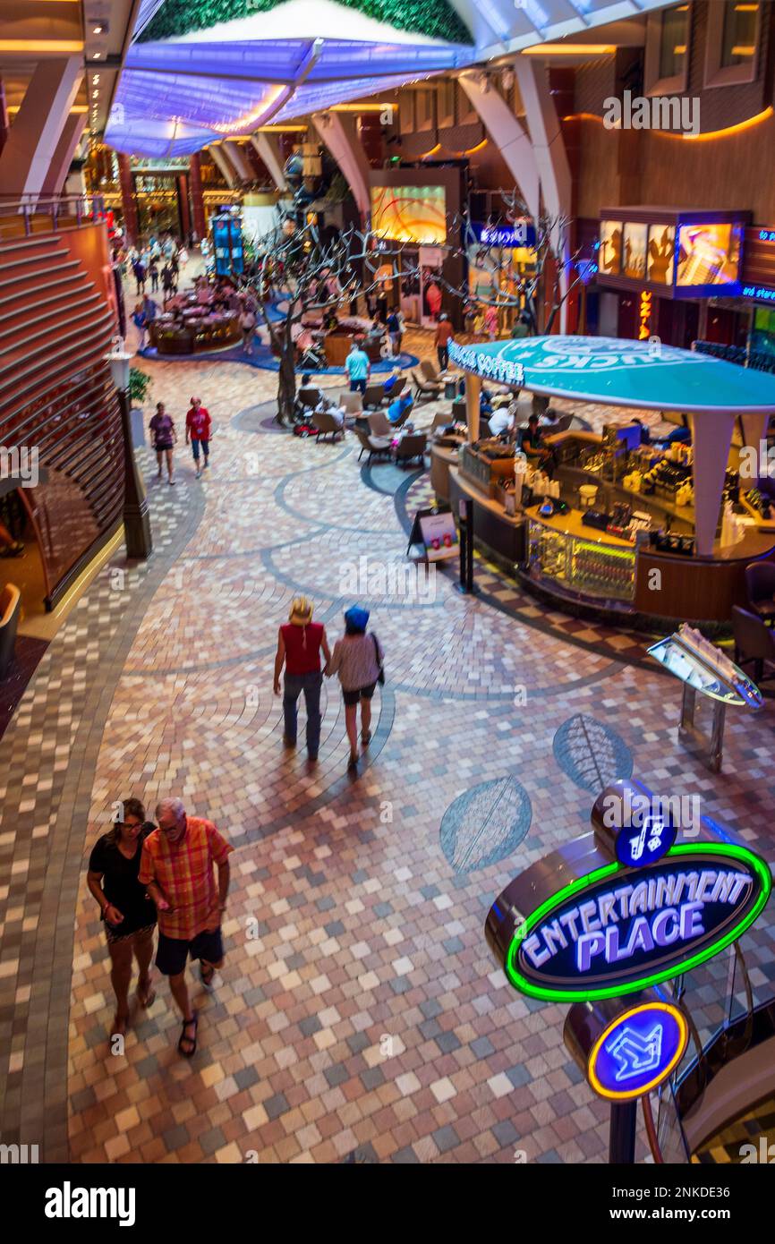 Tourists meander thru one of the Allure of the Seas many shopping areas ...