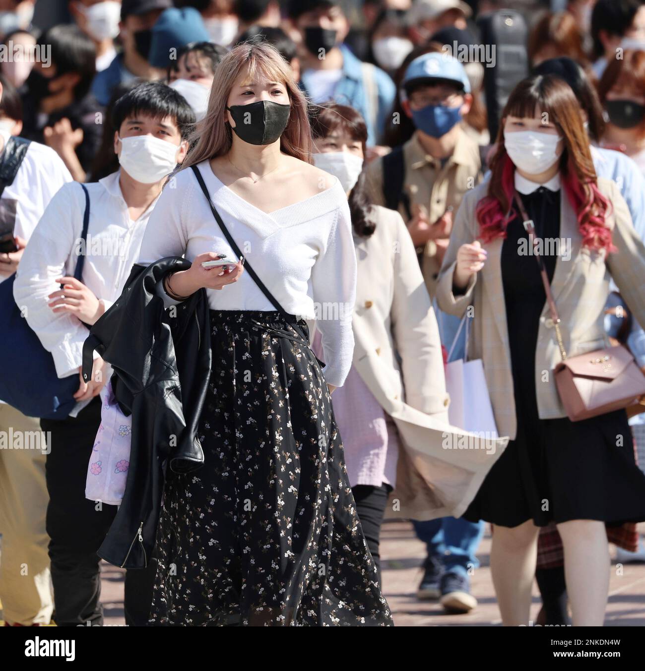 People take off their jaclets and coats in a warm weather in Shibuya ...