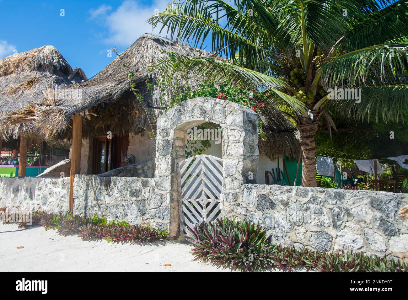 A stone wall separates a group of bungalows from the ocean, Costa Maya ...
