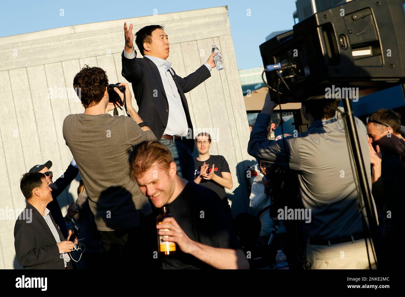 Presidential candidate Andrew Yang stands up on the table to ...
