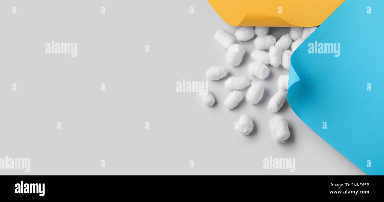 Soft cotton balls and color paper sheets on light background with space ...