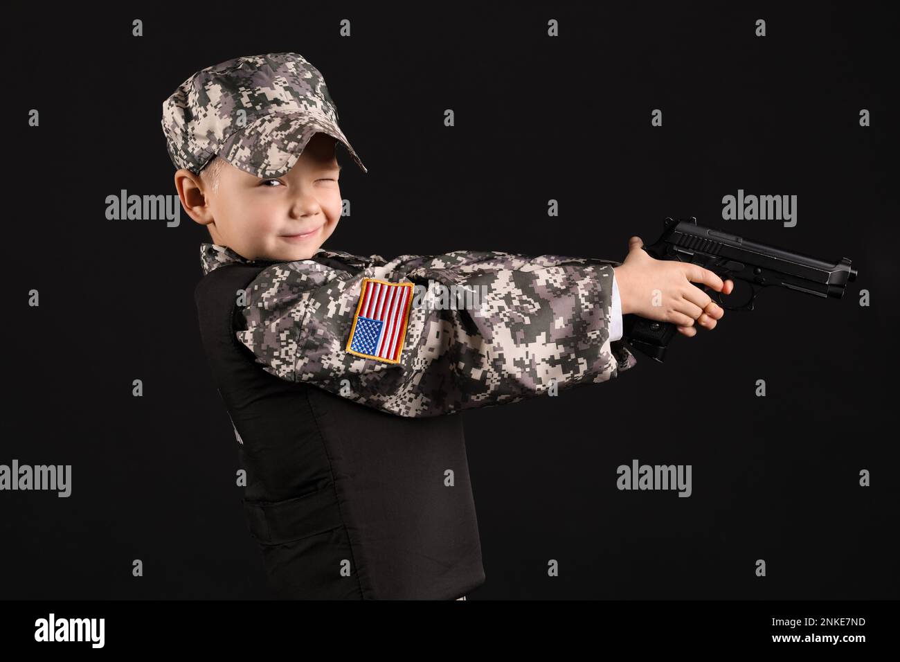 Cute little soldier with gun on black background Stock Photo - Alamy