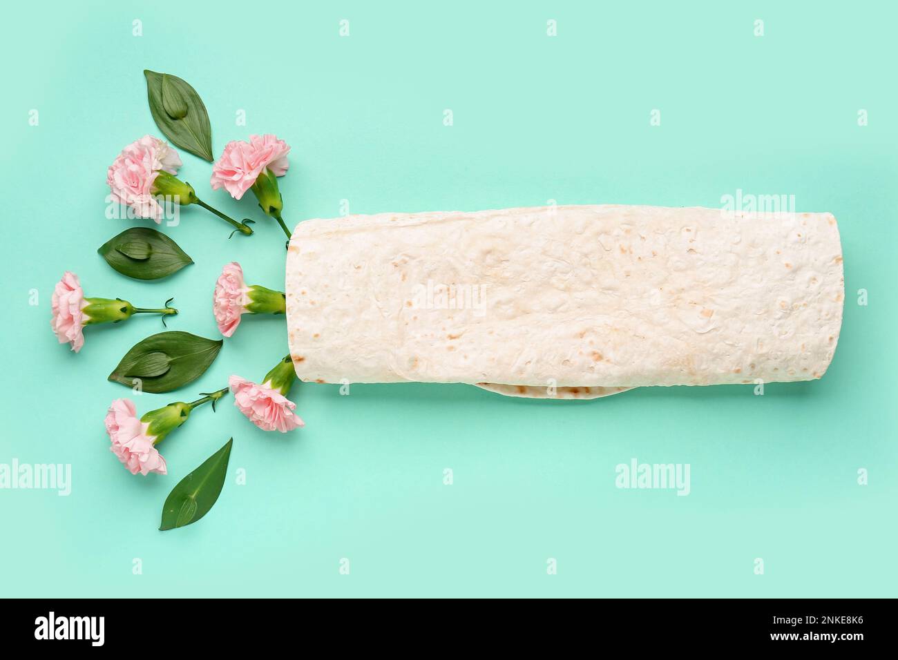 Creative composition with lavash, carnation flowers and plant leaves on ...