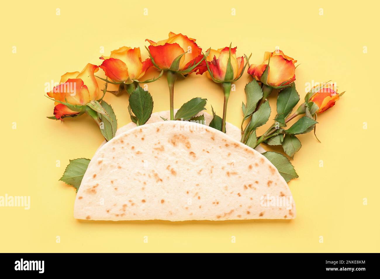 Creative composition with tortilla and beautiful rose flowers on yellow ...