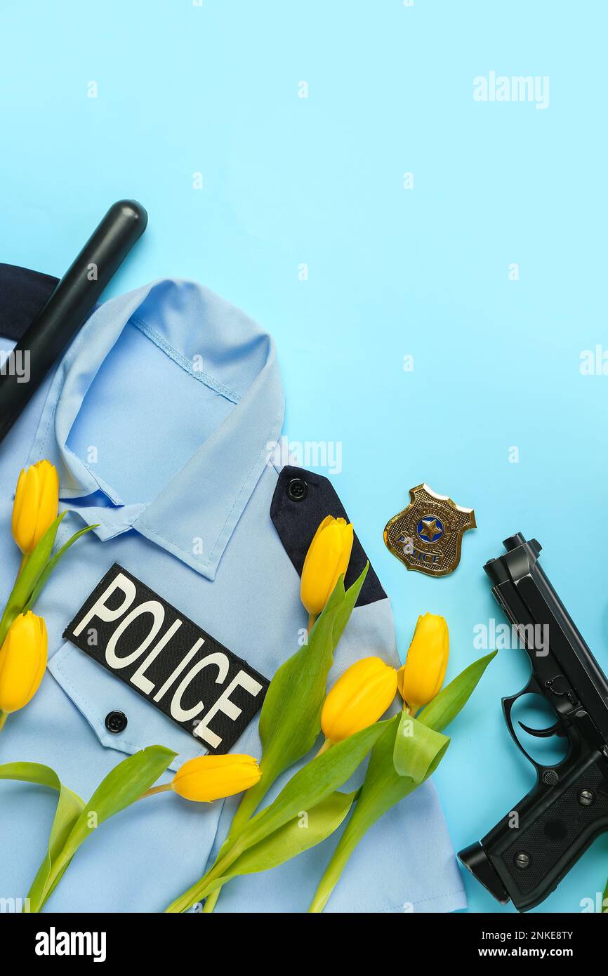 Policeman's uniform with badge, gun and tulips on blue background ...