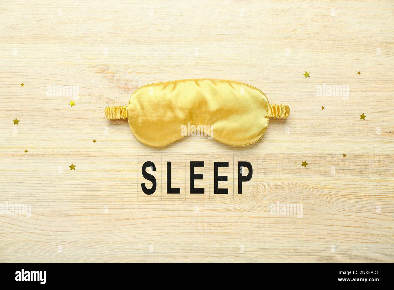 Composition with sleeping mask, word SLEEP and confetti on wooden ...