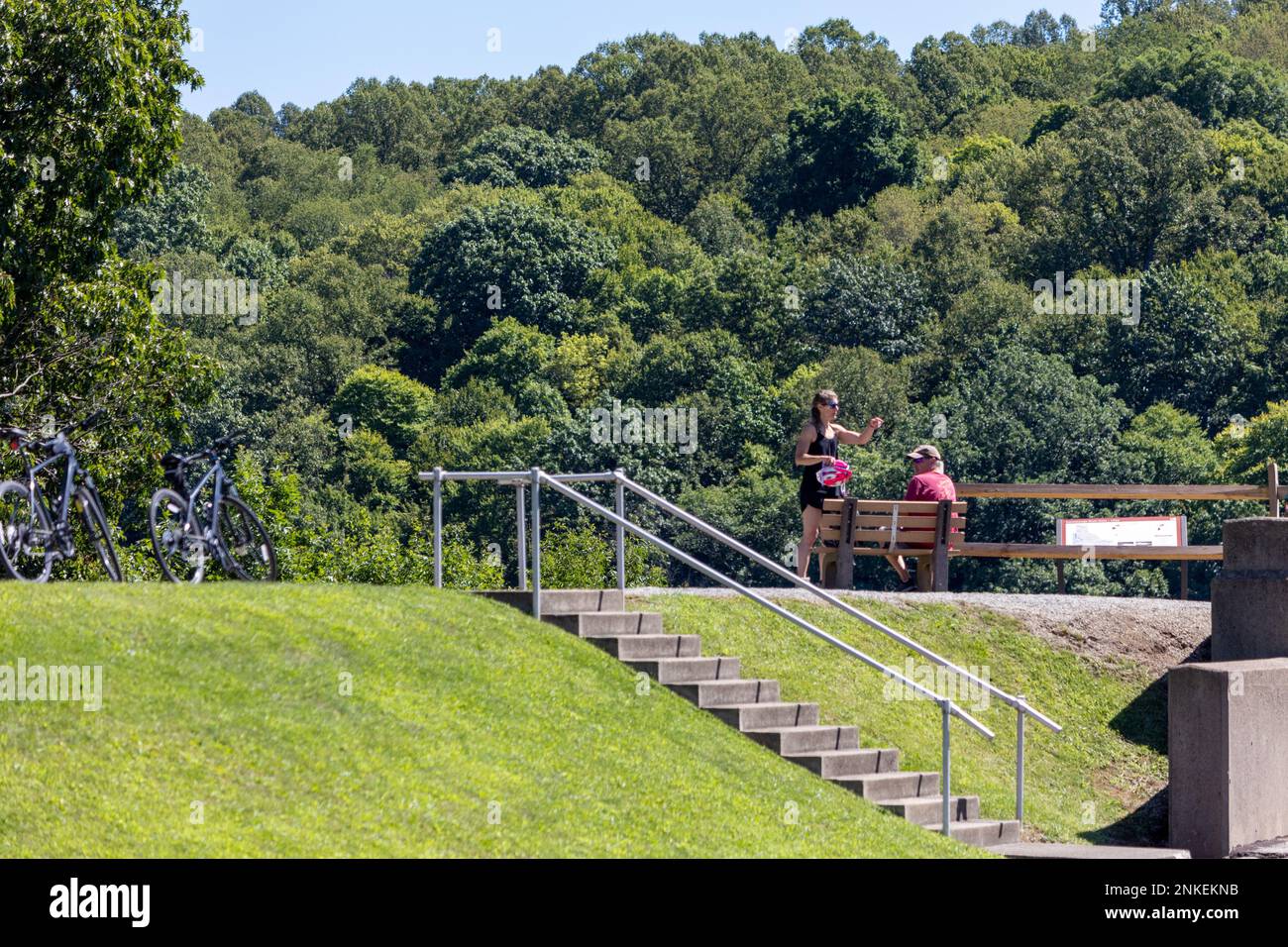 Cyclists take a break to enjoy the view of Conemaugh River Lake Dam in ...