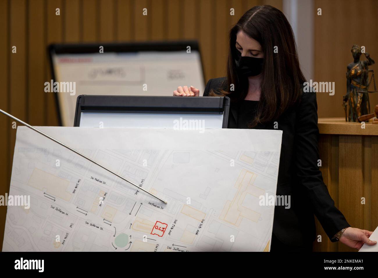Prosecutor Nicole Hermann observes as a witness uses a pointer to ...