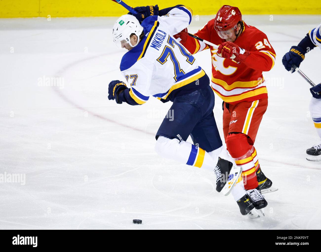 St. Louis Blues' Niko Mikkola, left, is checked by Calgary Flames ...