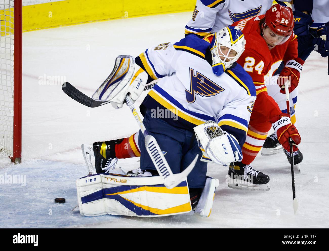 St. Louis Blues goalie Ville Husso, left, tries to stop Calgary Flames ...