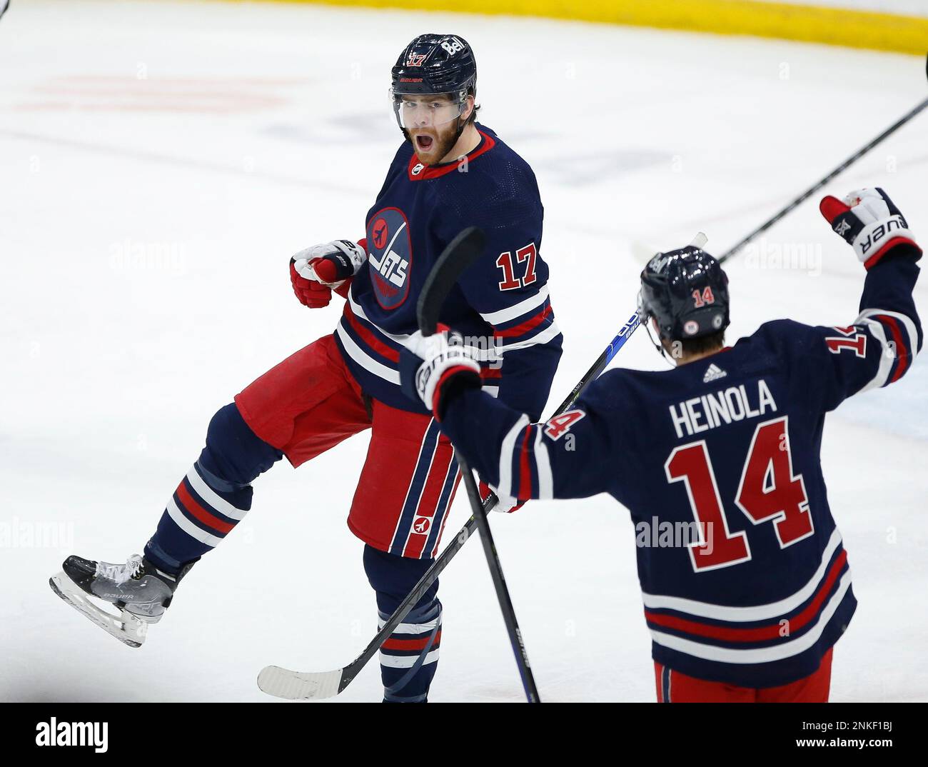 Winnipeg Jets' Adam Lowry (17) and Ville Heinola (14) celebrate Lowry's ...