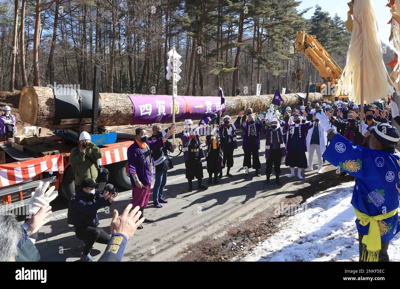 A huge tree is carried by a trailer truck for Onbashira Matsuri, also ...