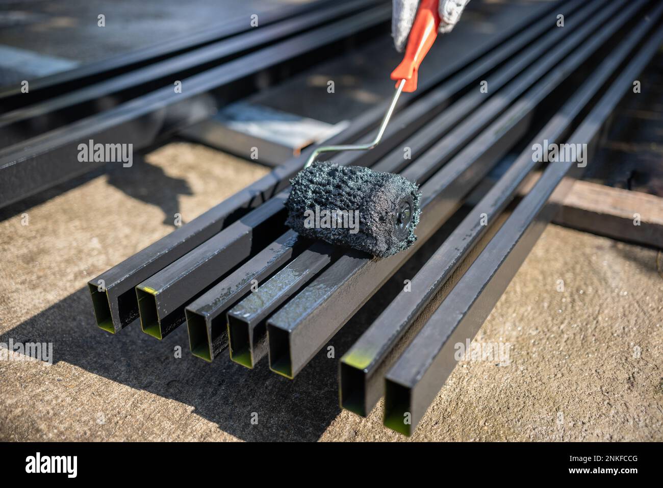 Worker painting steel post in construction site Stock Photo - Alamy