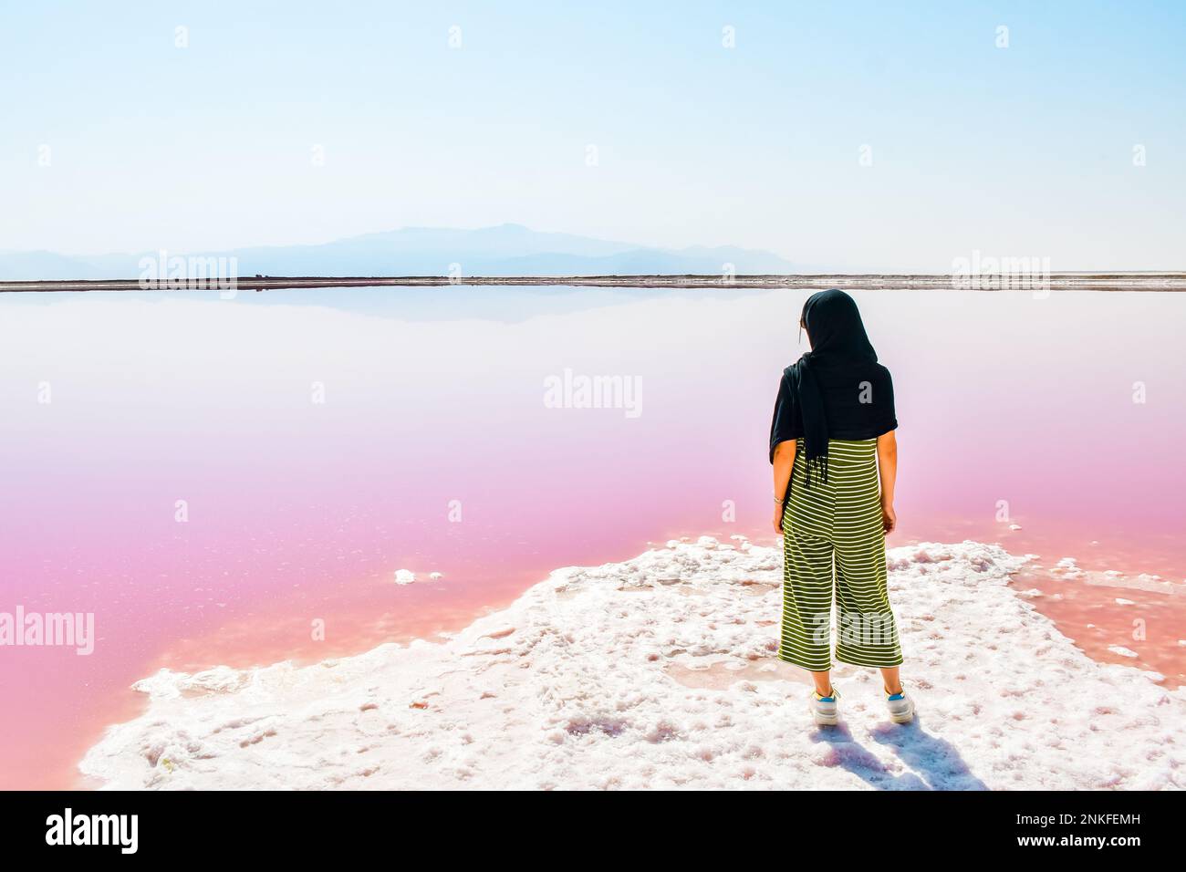 Caucasian woman tourist stand on Maharlu pink salt lake shore. Travel ...
