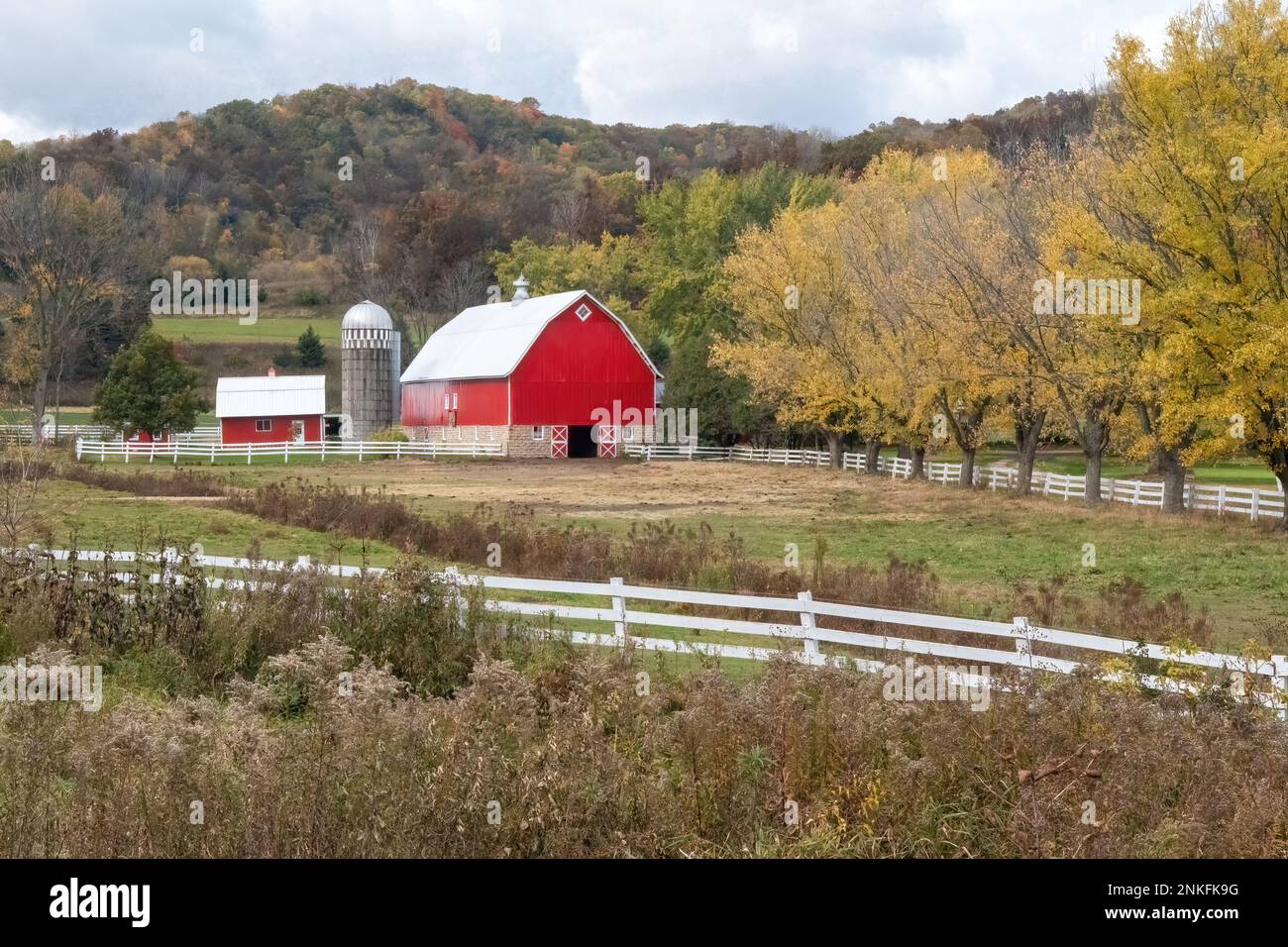 Beautiful scenic farm with a red barn and white fences and bluffs ...