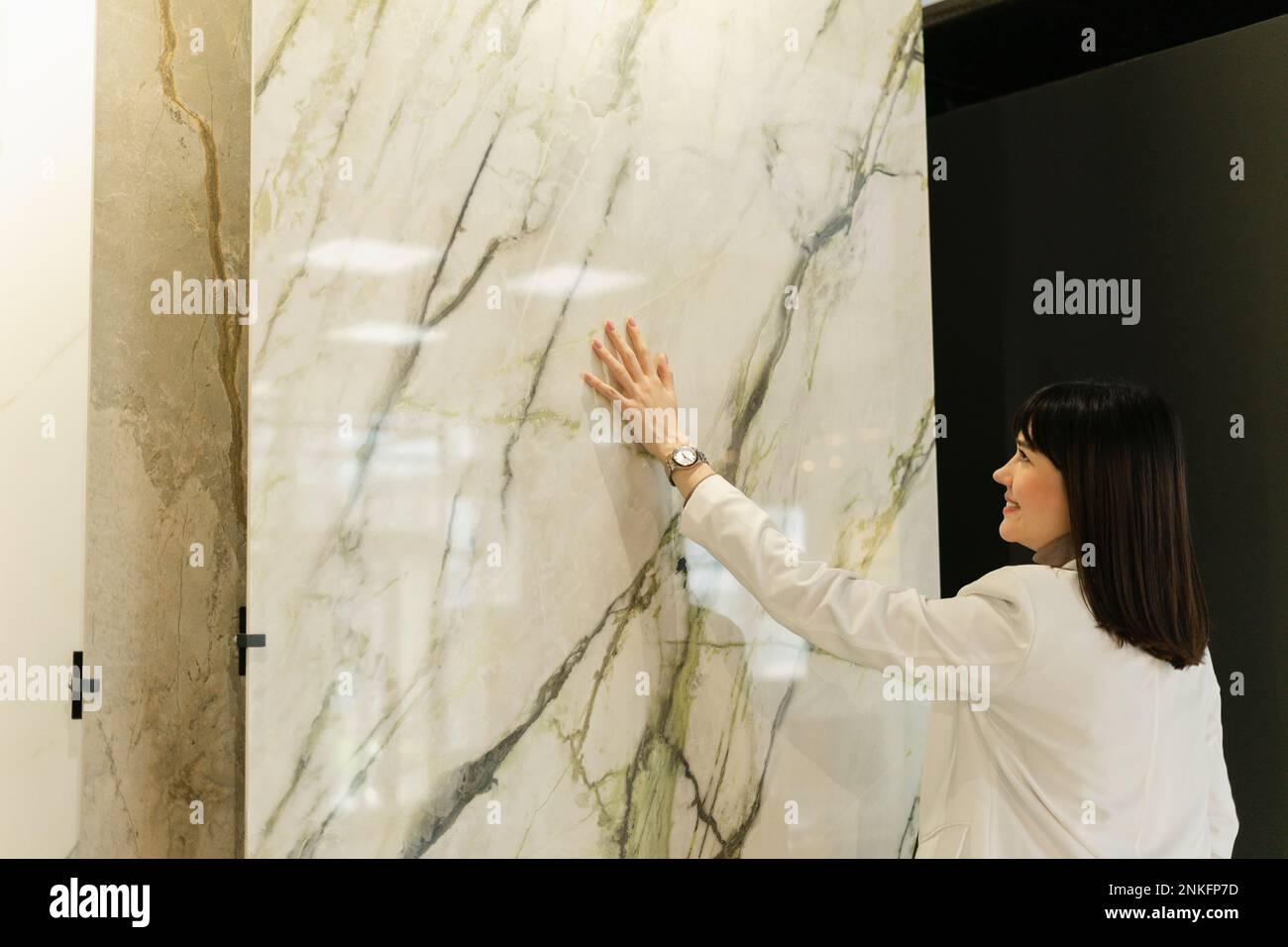 Woman touching marble plate in showroom Stock Photo - Alamy