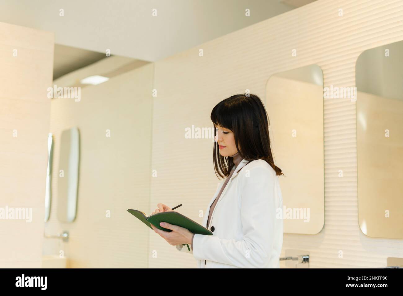 Woman taking notes in bathroom showroom Stock Photo - Alamy