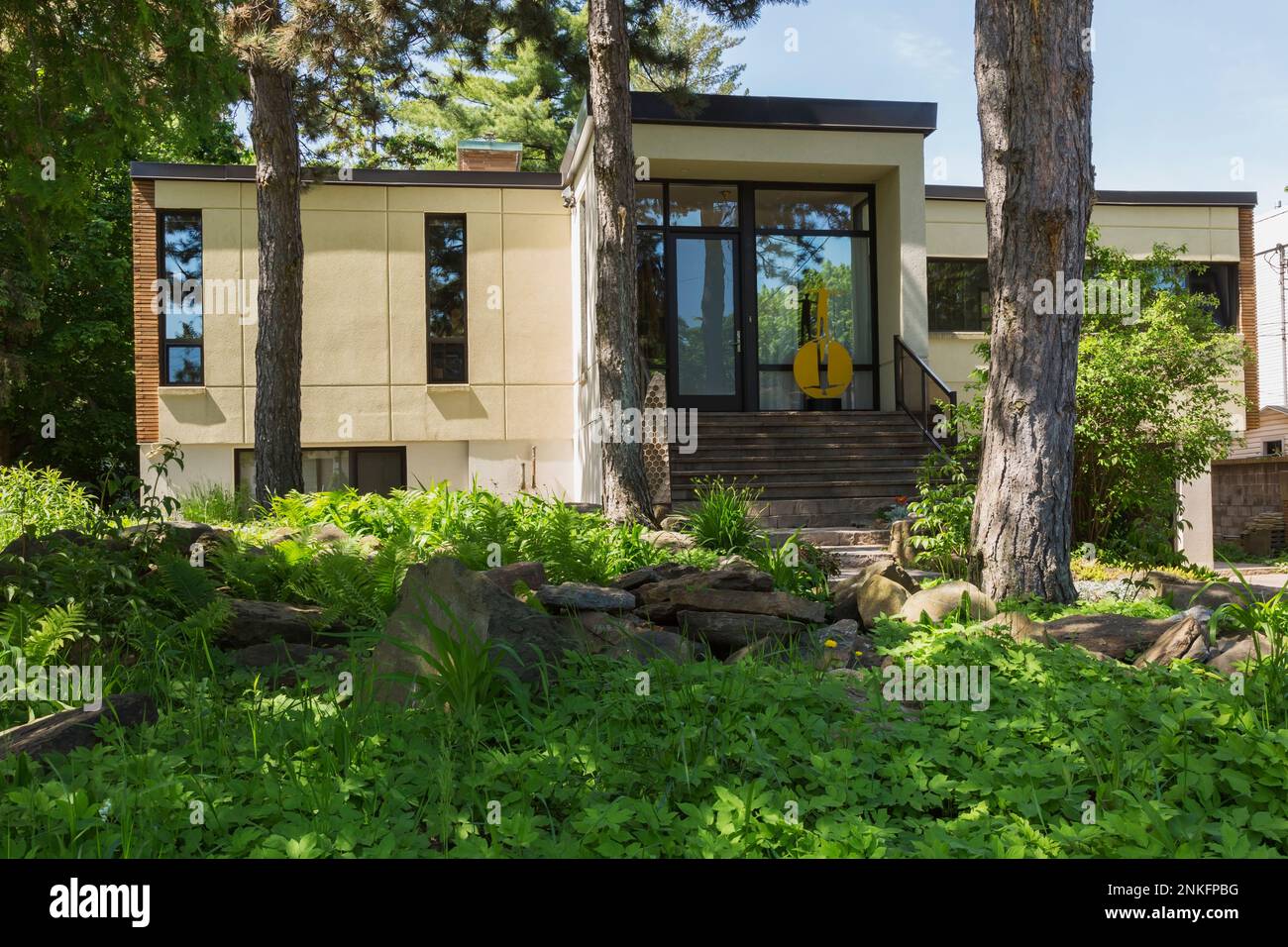 Contemporary cube style home facade with beige cement panels and brick ...