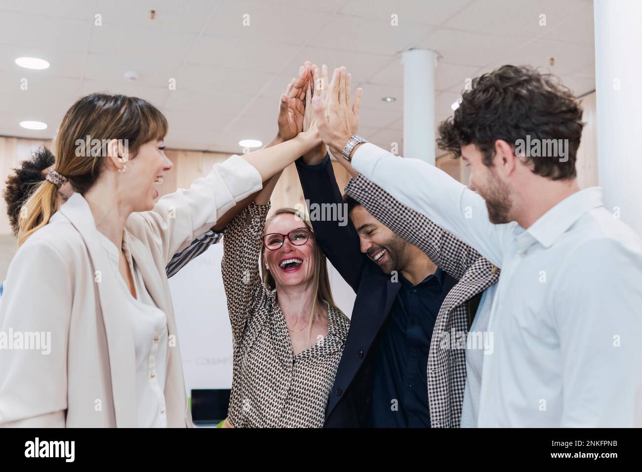Happy business colleagues high fiving in office Stock Photo - Alamy