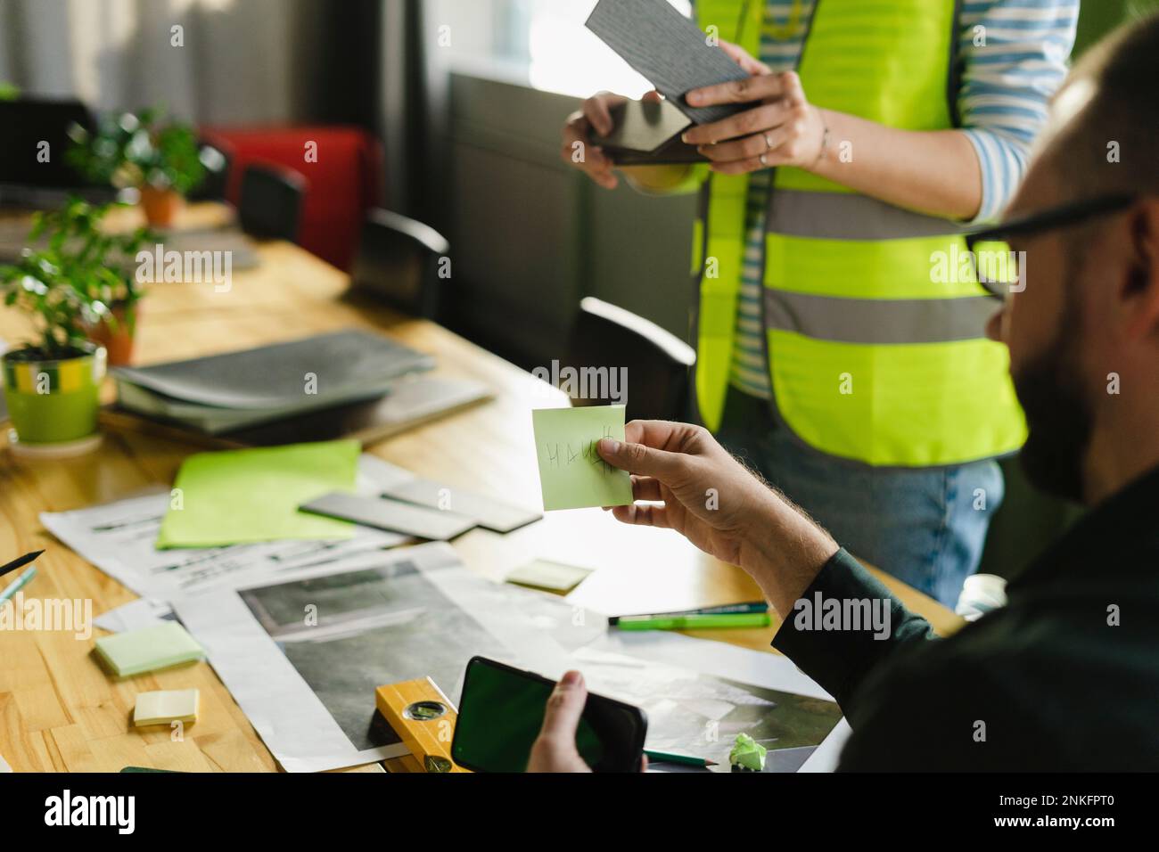Businessman holding slip of paper and engineer having a meeting in ...