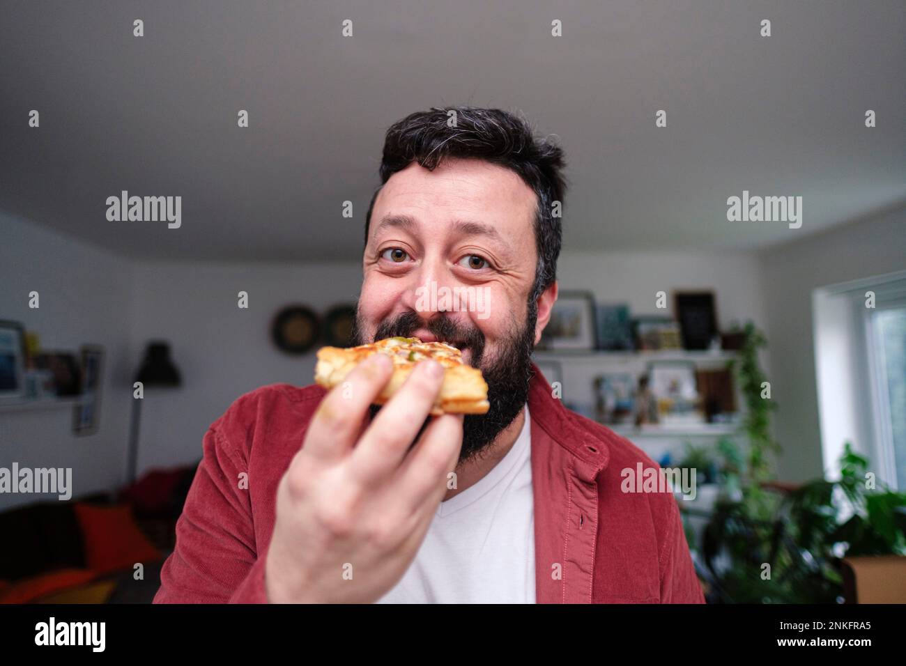 Happy man eating pizza at home Stock Photo - Alamy