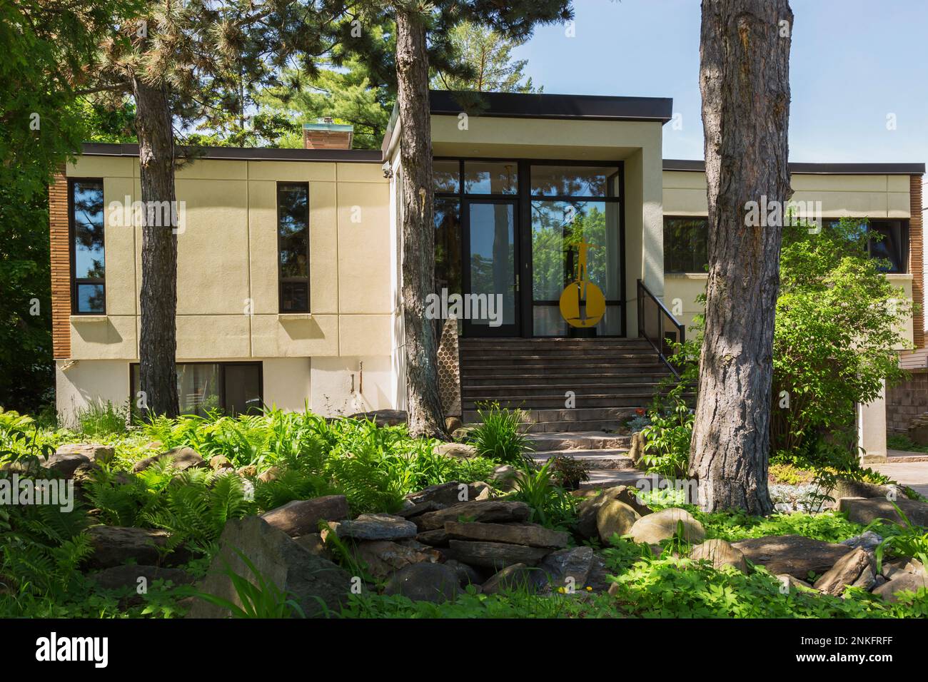 Contemporary cube style home facade with beige cement panels and brick ...