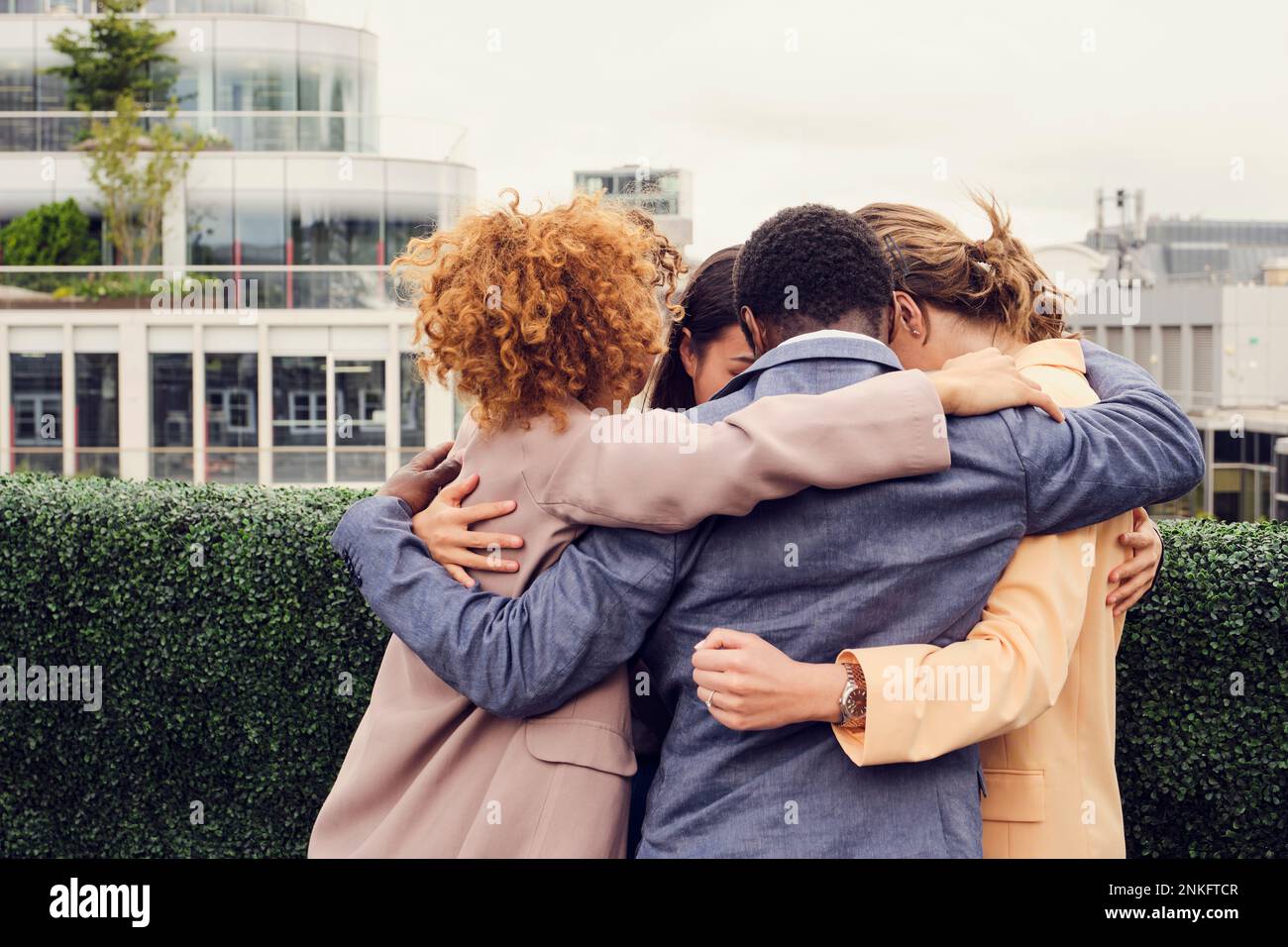 Multiracial business colleagues huddling together Stock Photo - Alamy