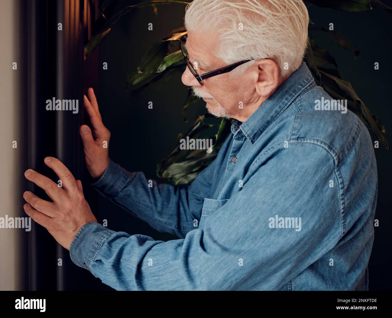 Senior man touching radiator at home Stock Photo - Alamy