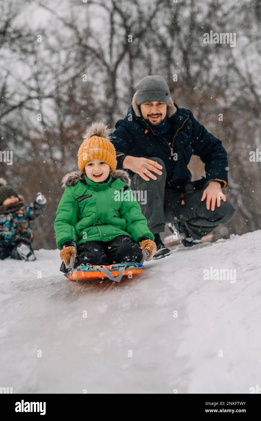 Boy sledding down hill hi-res stock photography and images - Alamy