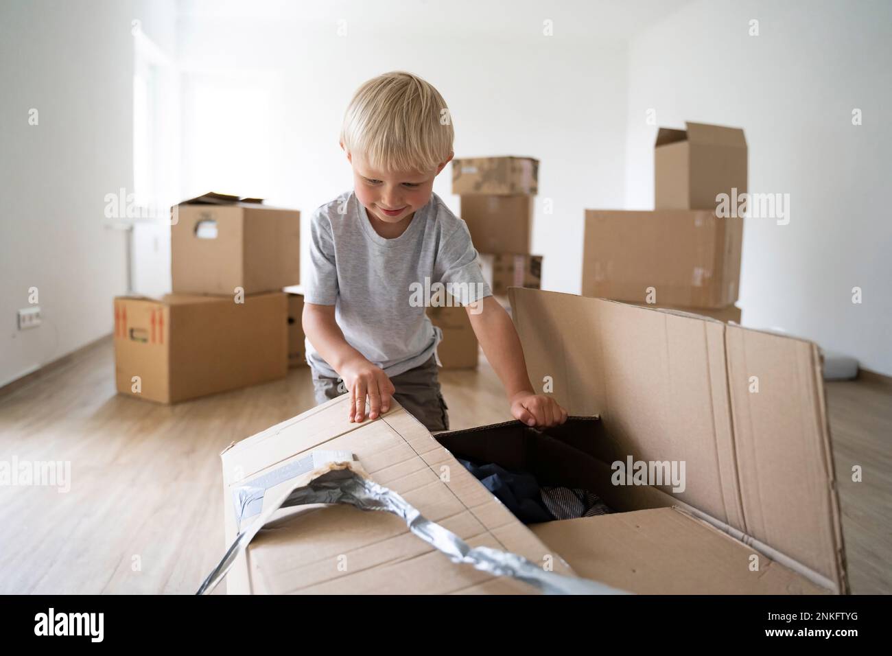 Boy opening cardboard at home Stock Photo - Alamy