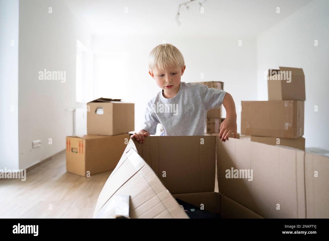 Boy opening cardboard box at home Stock Photo - Alamy