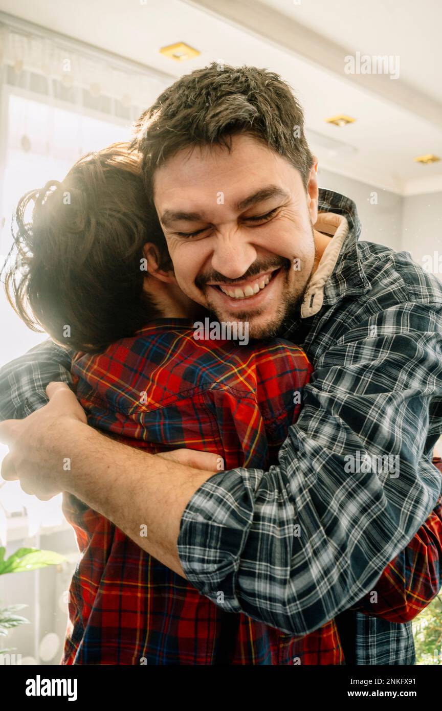 Cheerful father hugging son at home Stock Photo - Alamy