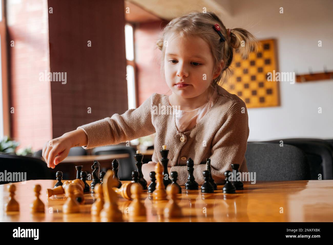 Cute girl playing chess at club house Stock Photo - Alamy