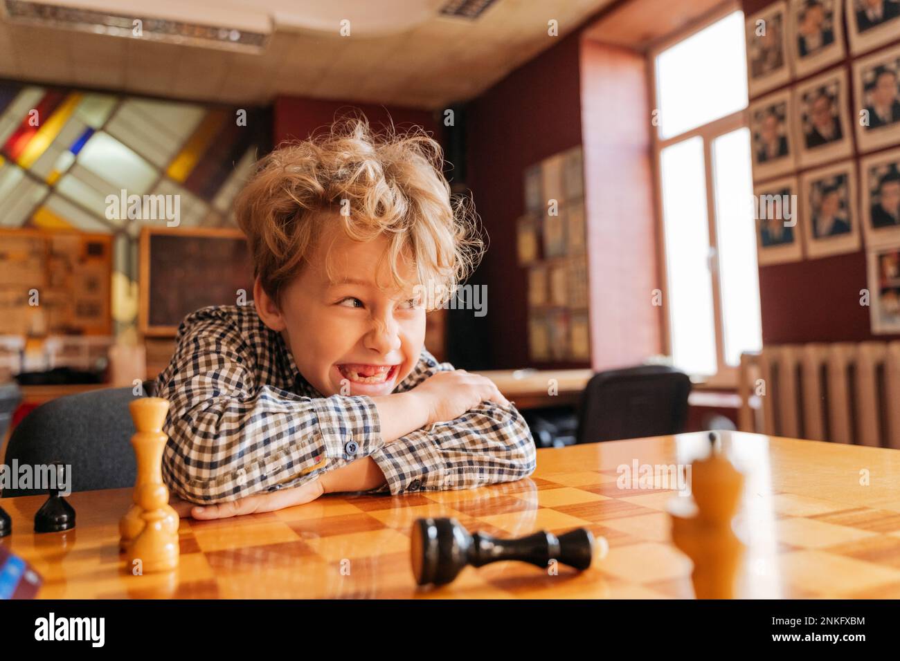 Boy sitting at table playing chess in country club Stock Photo - Alamy