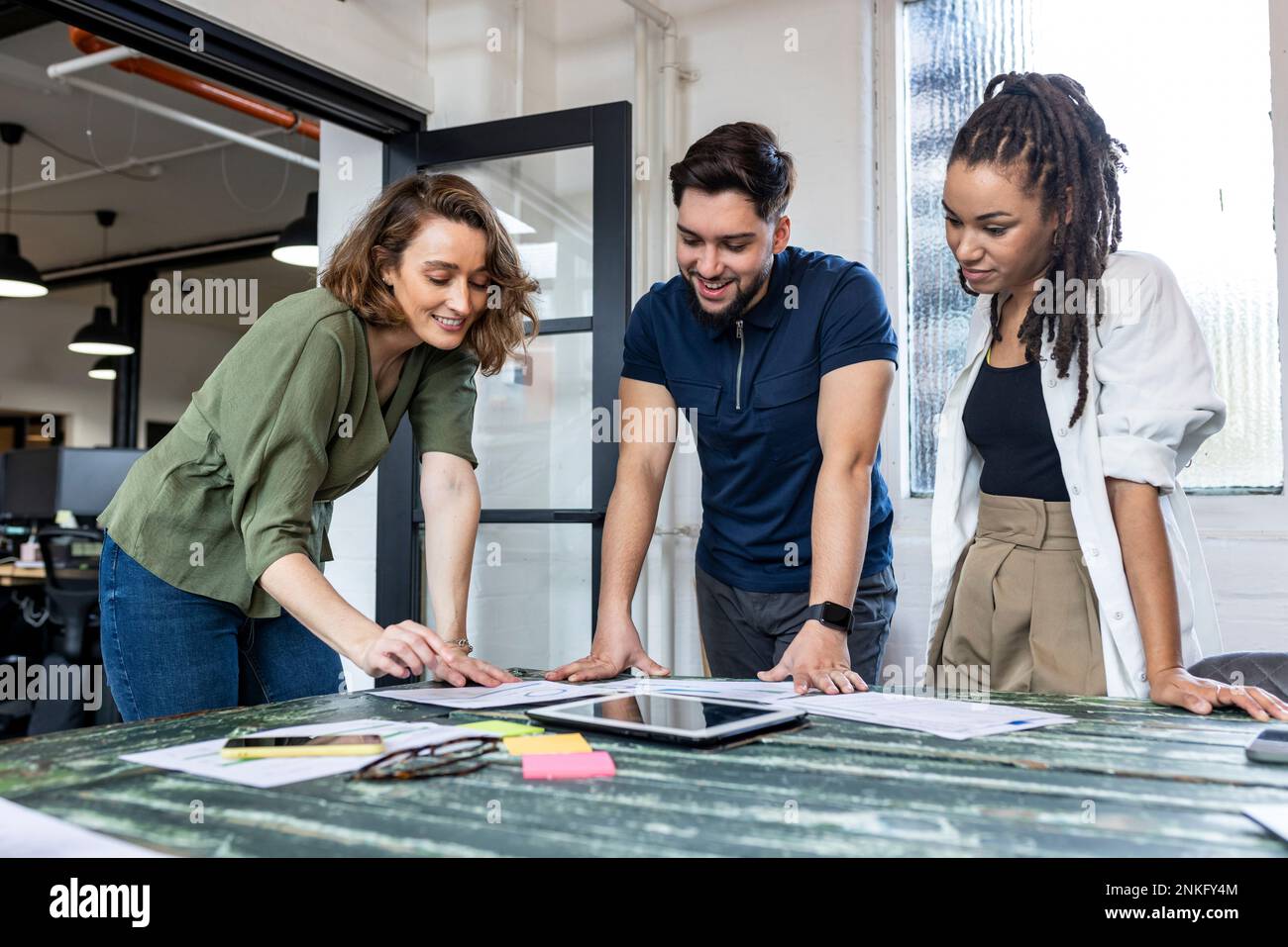 Happy business people with charts and graphs standing by table in ...