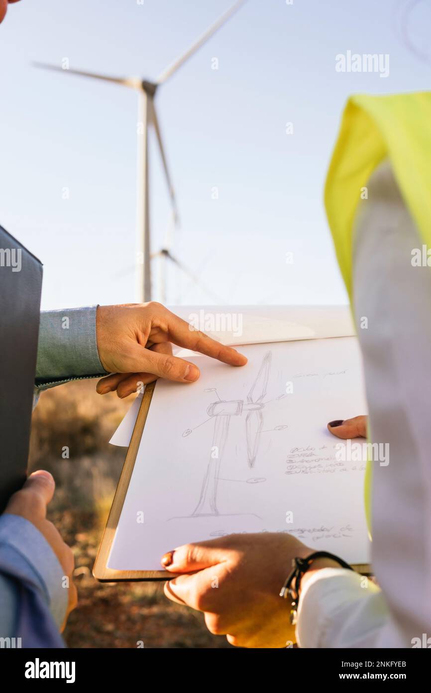 Engineers discussing over wind turbine diagram Stock Photo - Alamy