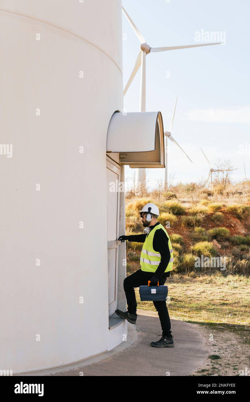 Technician with toolbox entering wind turbines Stock Photo - Alamy
