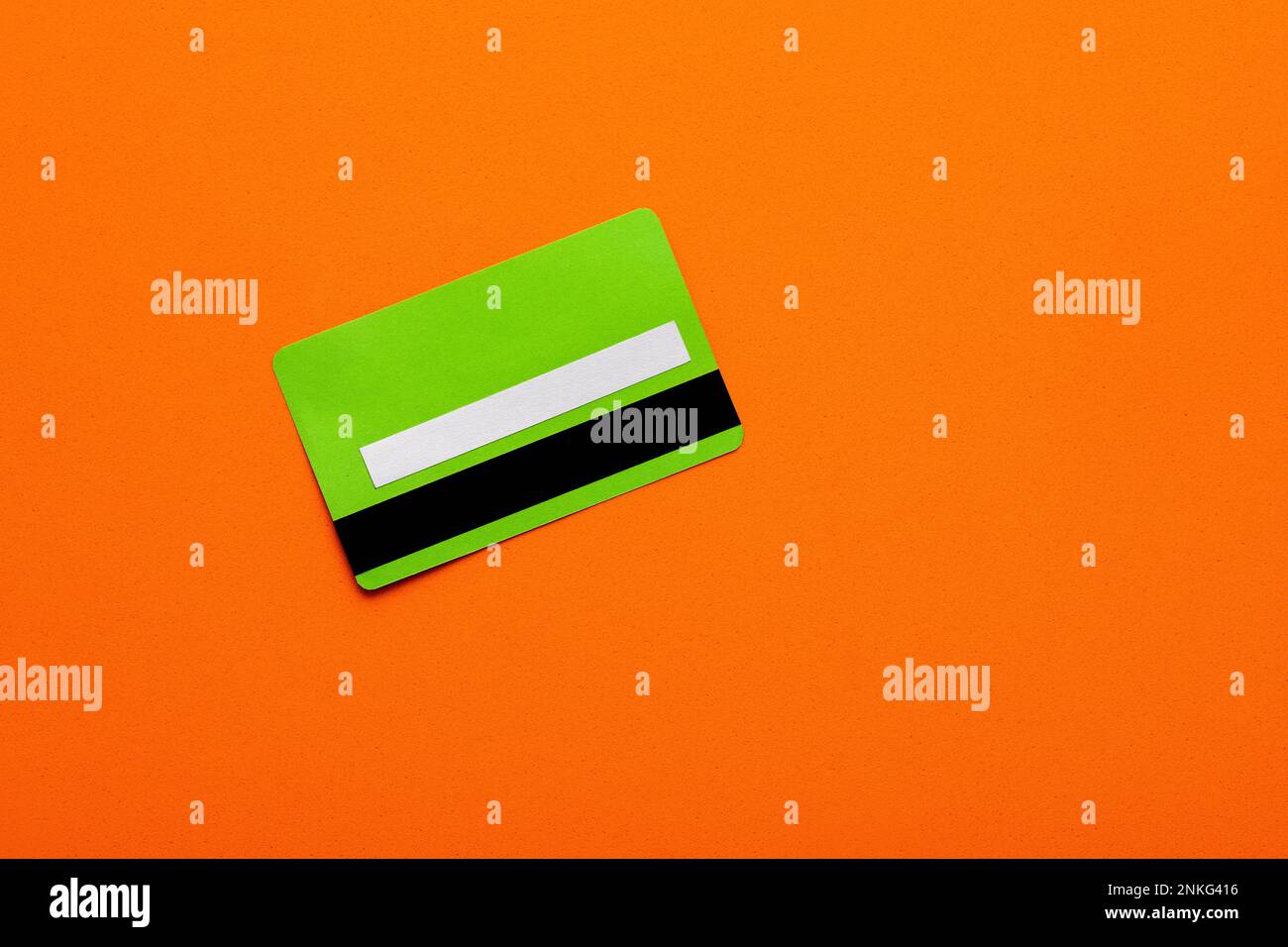 Green debit or credit card on orange background - Concept of good ...