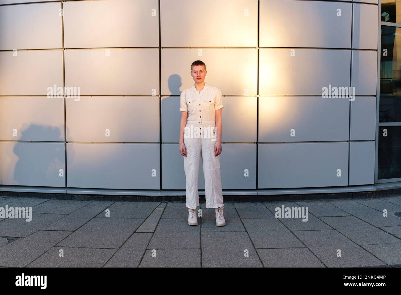 Non-binary person standing in front of building Stock Photo - Alamy